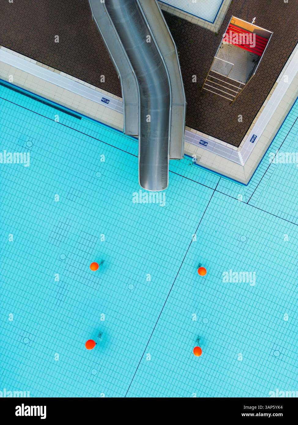 Aerial view of vibrant public pools with geometric patterns and slides ...