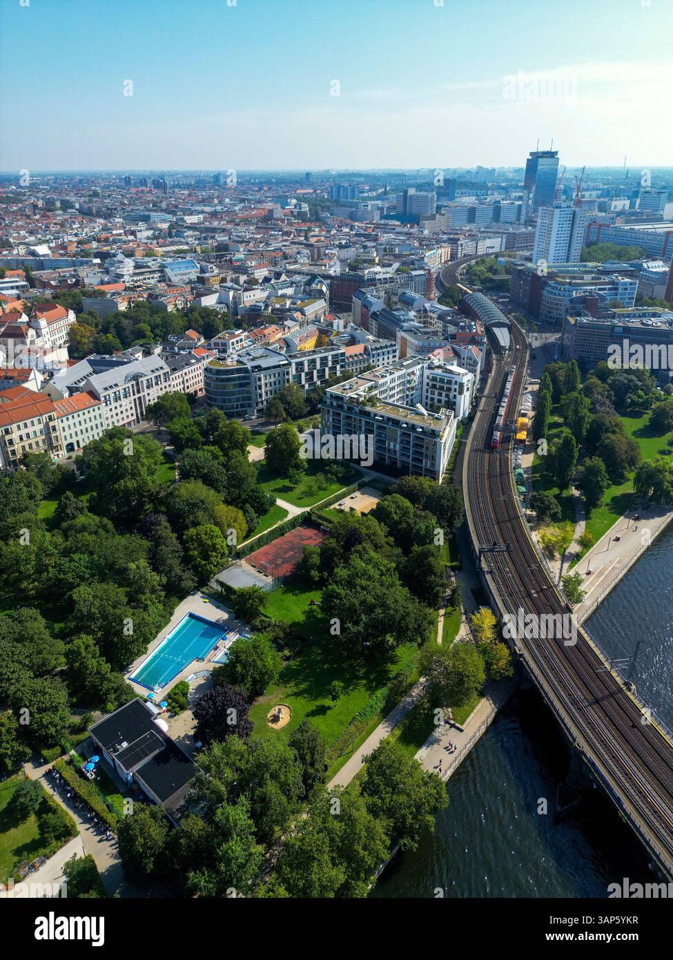 Aerial view of vibrant public pools and lush greenery amidst urban ...