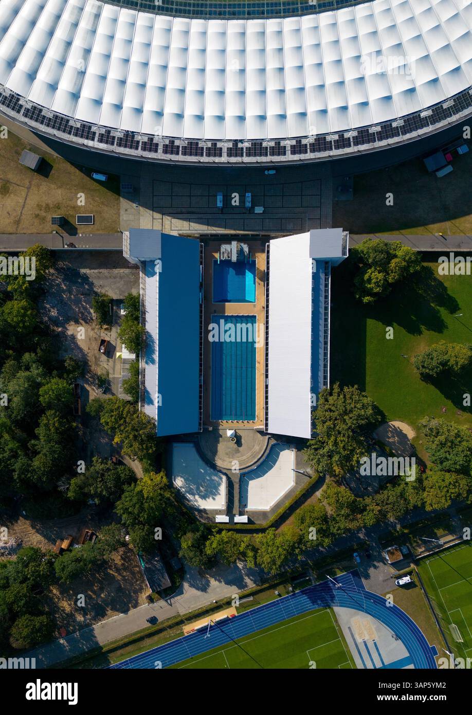 Aerial view of modern public pools and stadium surrounded by greenery ...