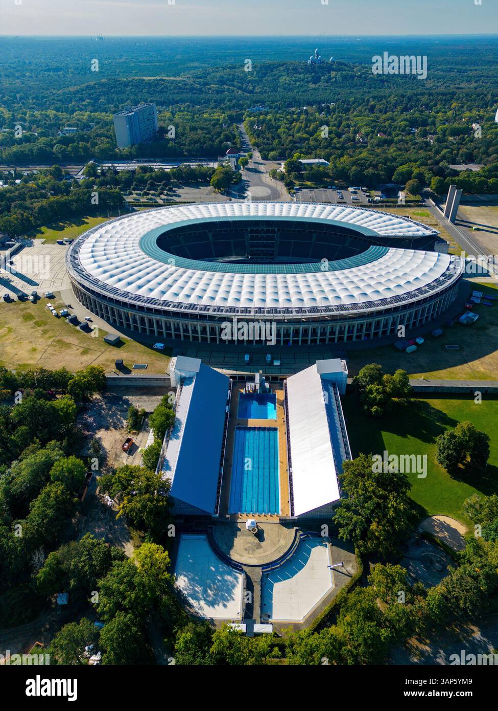 Aerial view of public pools and stadium surrounded by greenery and ...