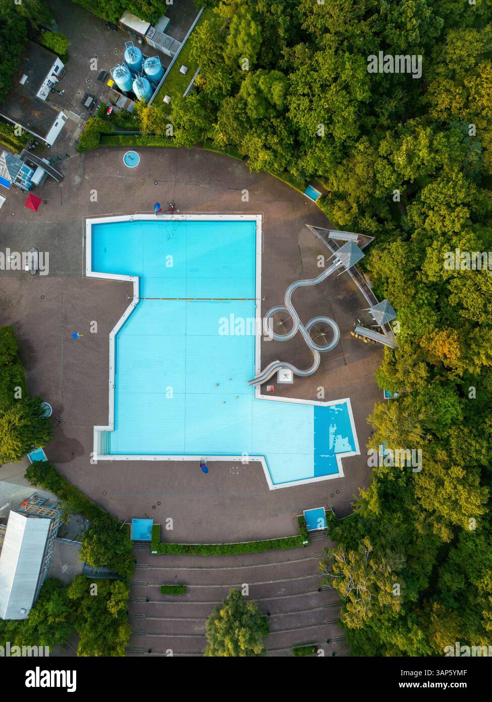 Aerial view of public pools surrounded by greenery and trees, Neukolln ...
