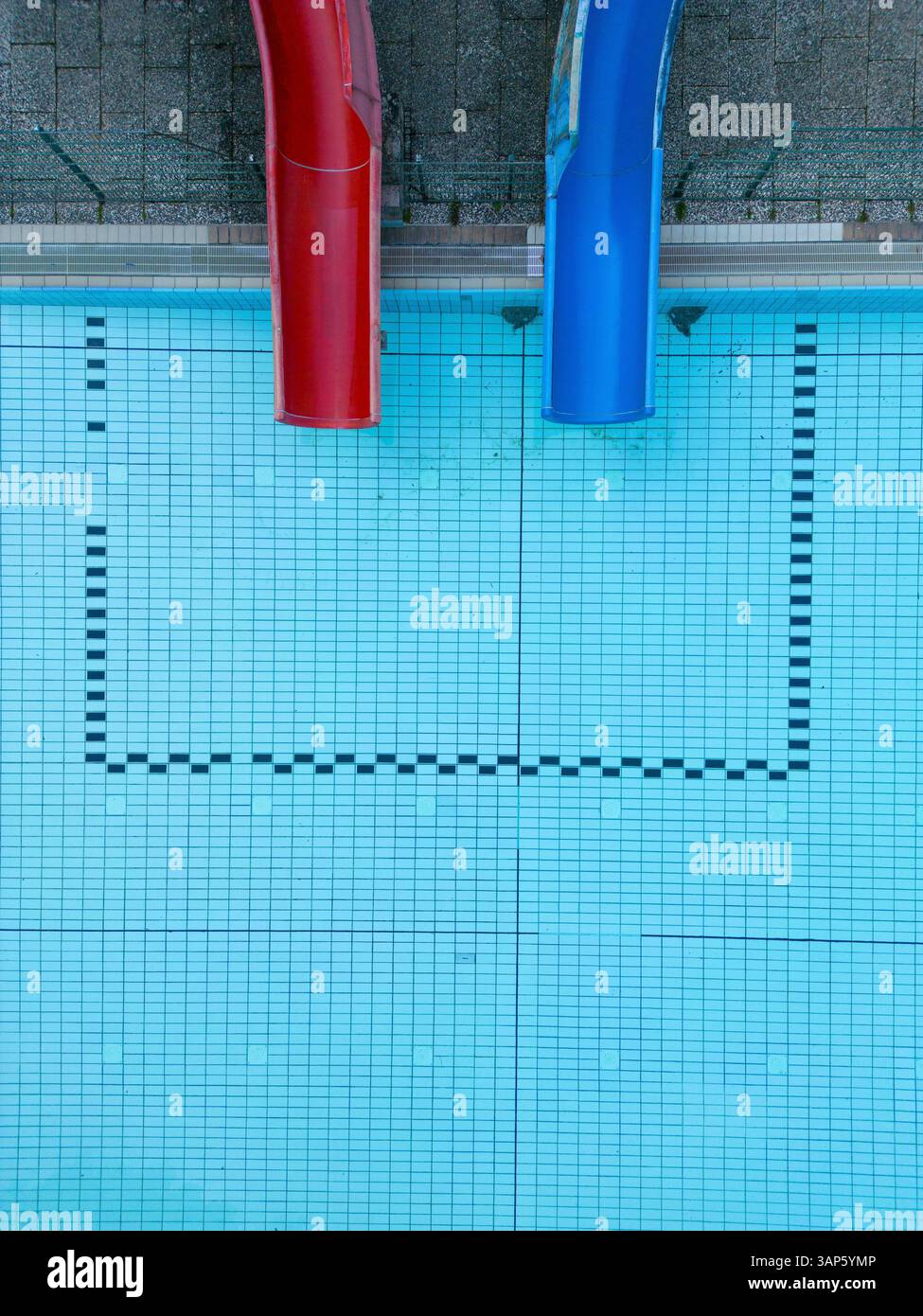 Aerial view of vibrant public pools with colorful slides and families ...