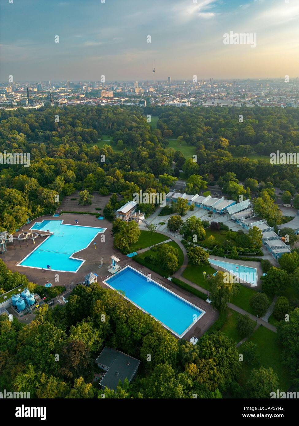 Aerial view of public pools surrounded by urban greenery and cityscape ...