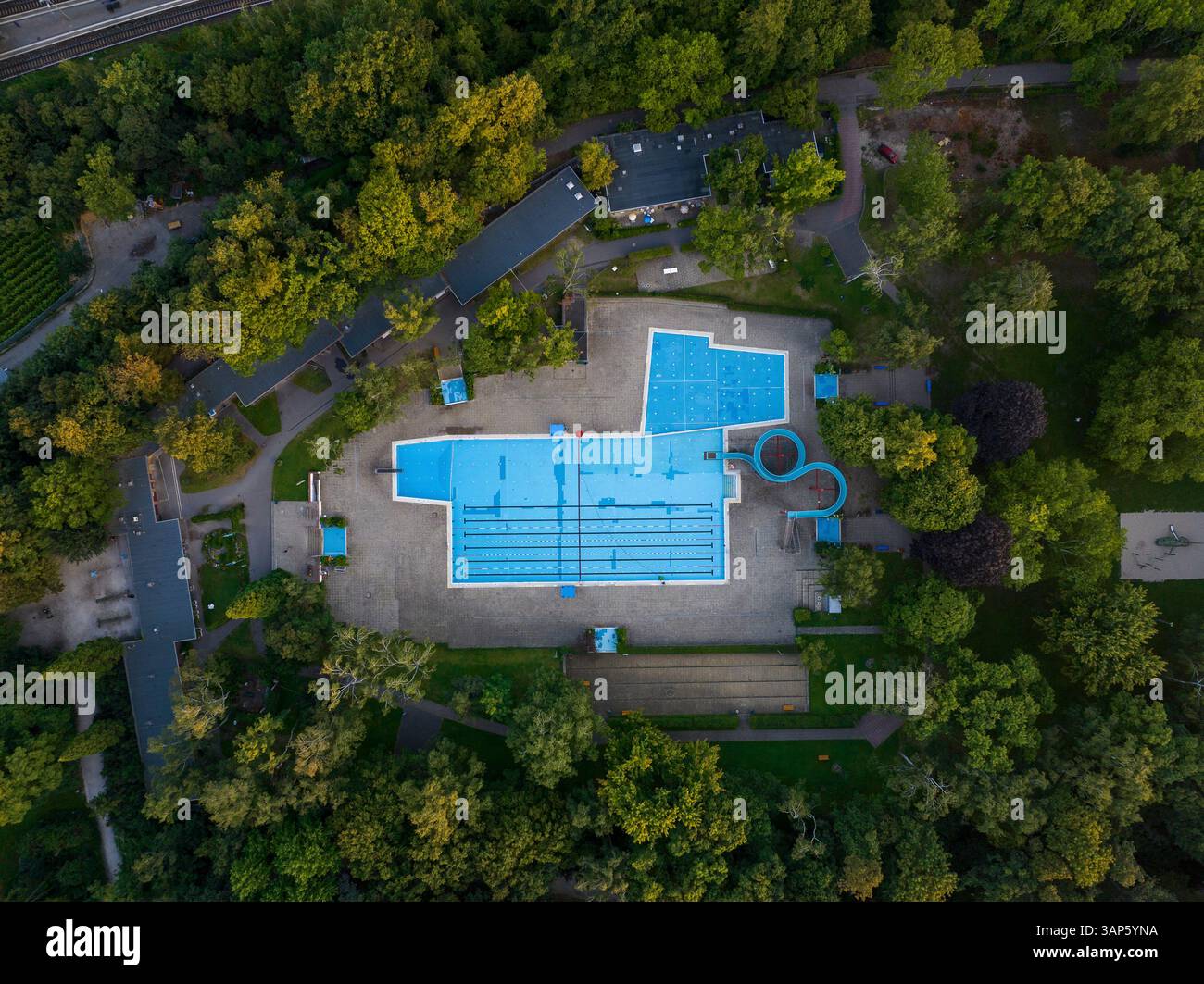 Aerial view of public pools surrounded by greenery and trees in a ...