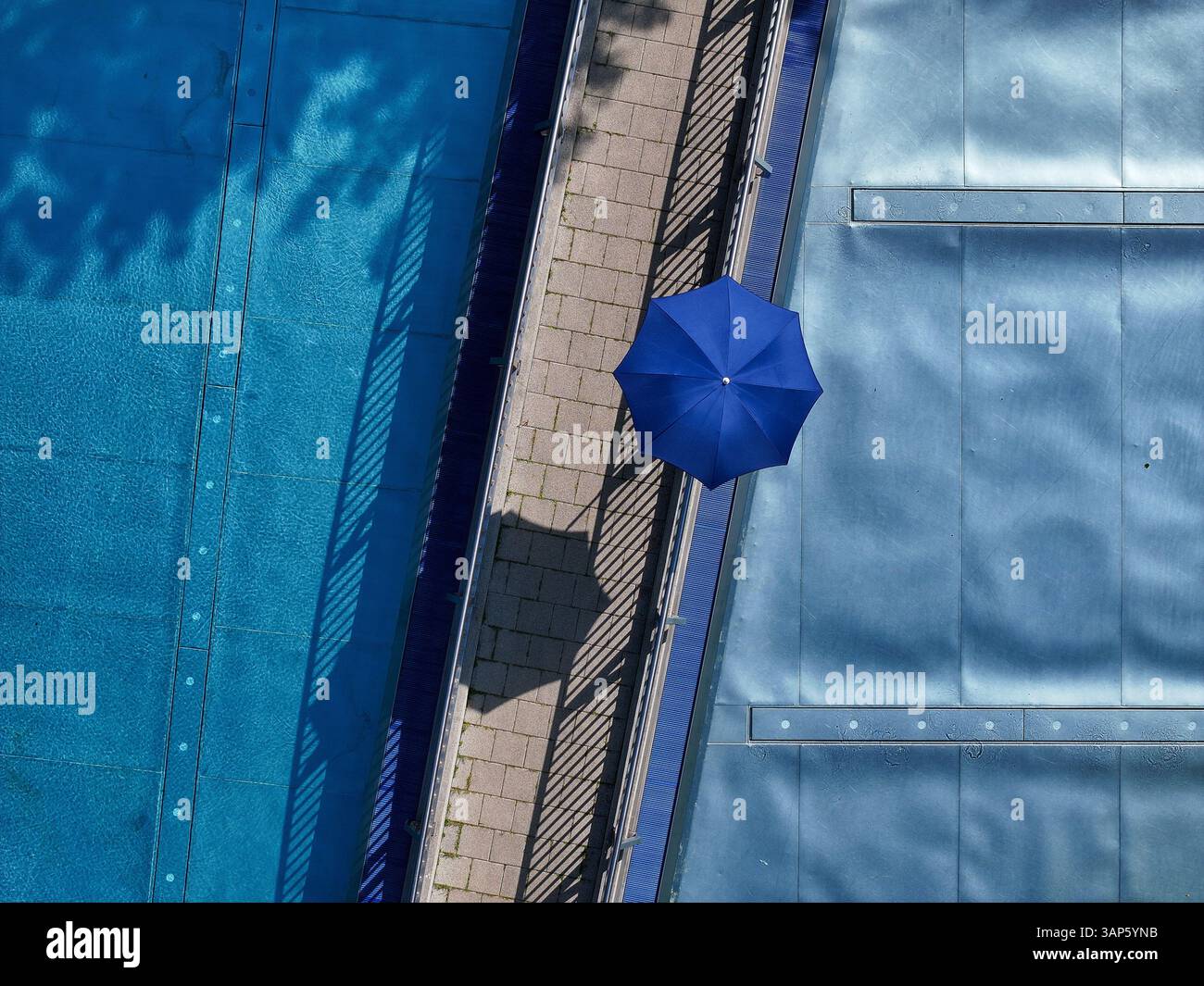 Aerial view of public pools with blue water and umbrellas in summer ...