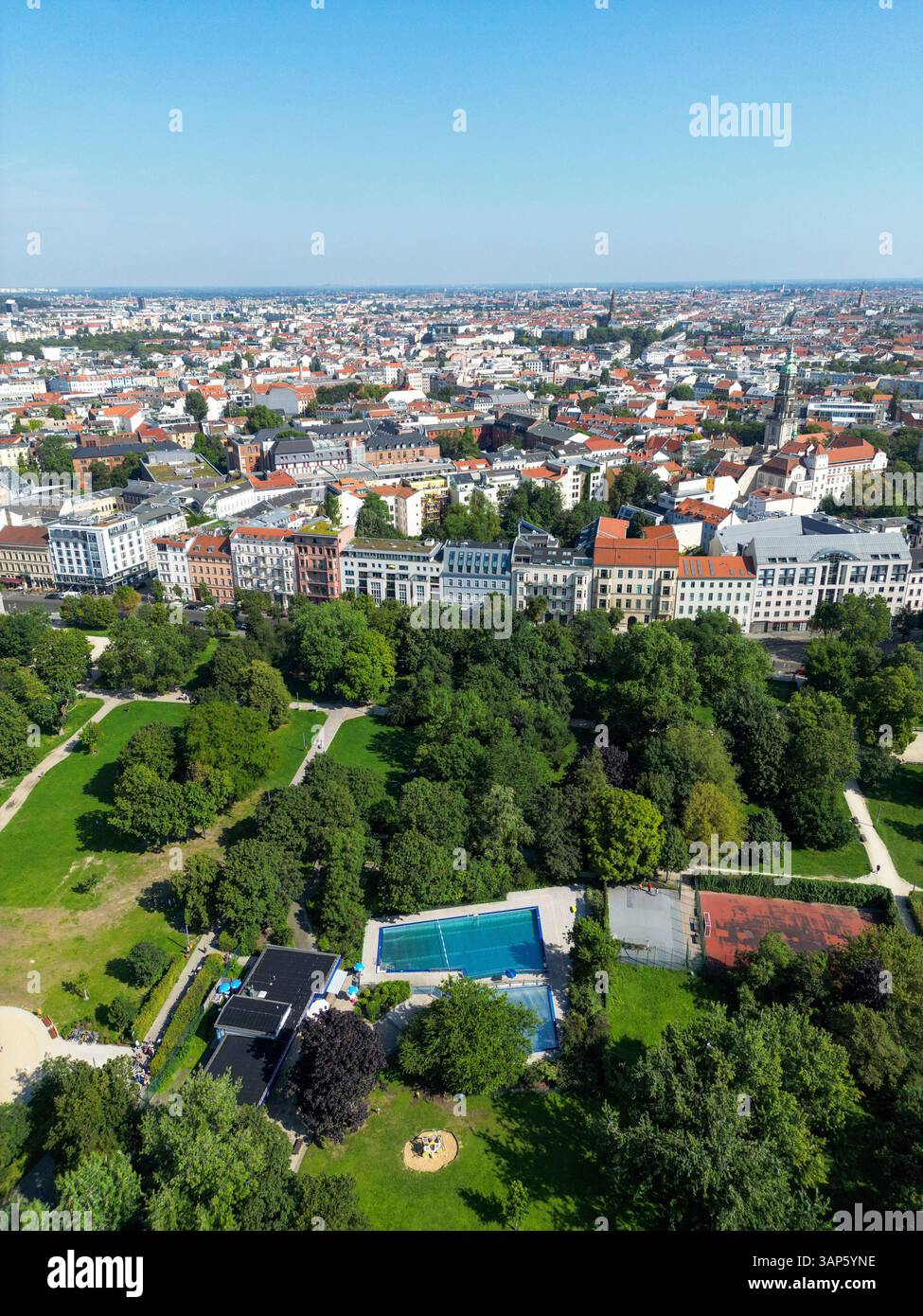 Aerial view of public pools surrounded by greenery and buildings in a ...
