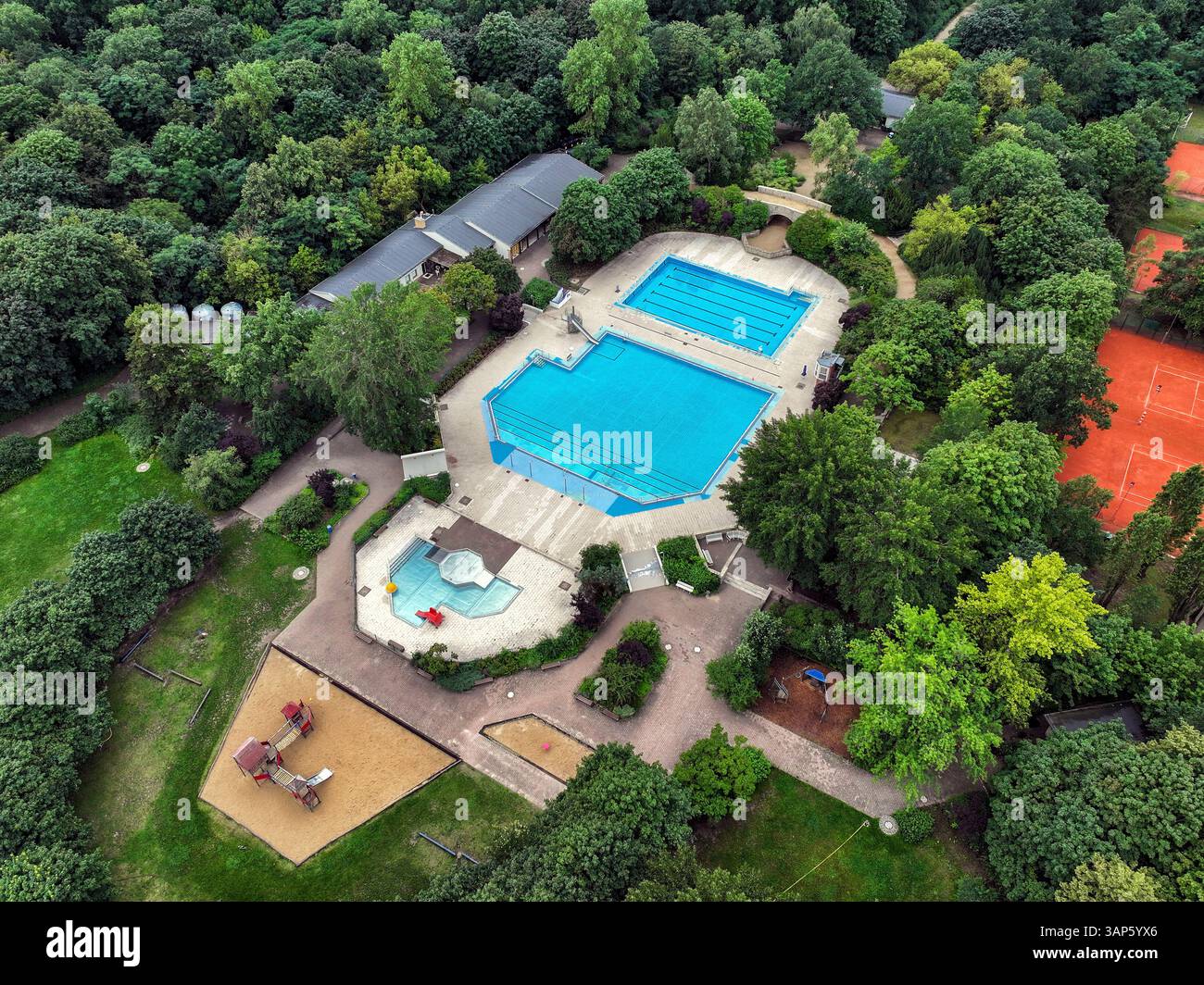 Aerial view of a beautiful public pool surrounded by greenery and trees ...