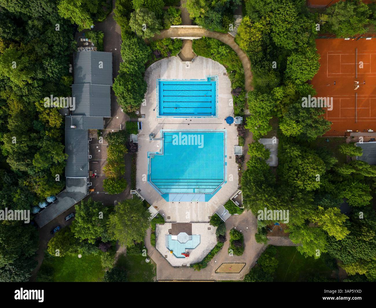 Aerial view of a beautiful public swimming pool surrounded by greenery ...
