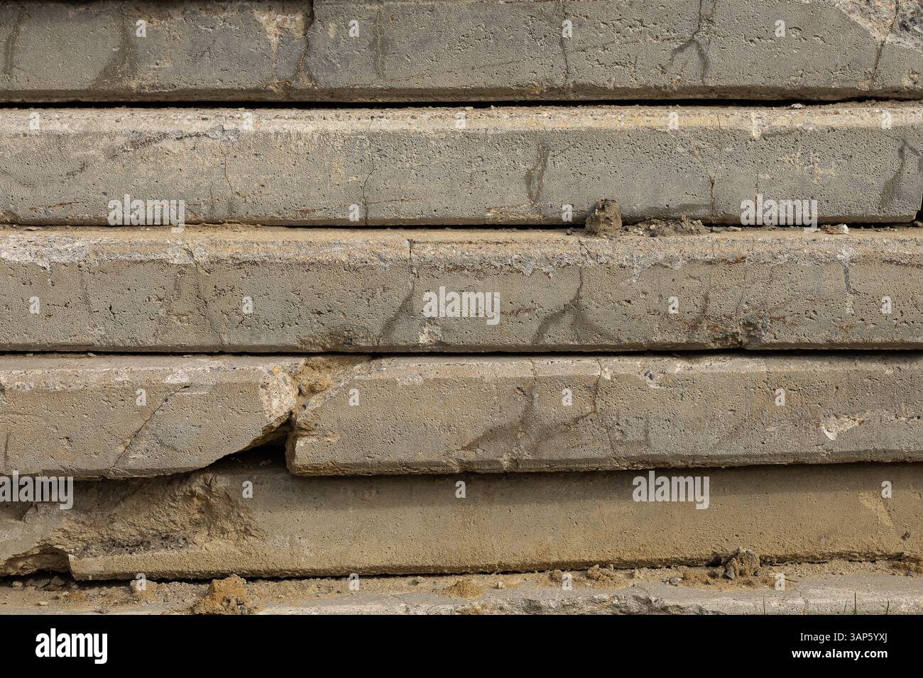 Stack of rough cracked concrete slabs with visible texture, dirt and ...