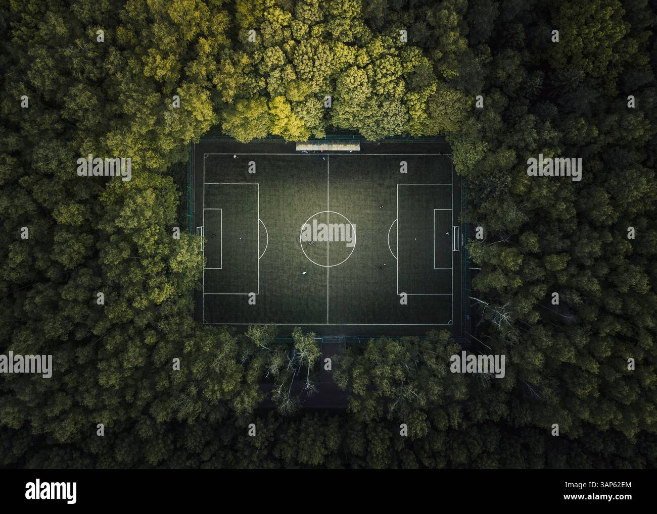 Aerial view of a football field with people playing soccer surrounded ...