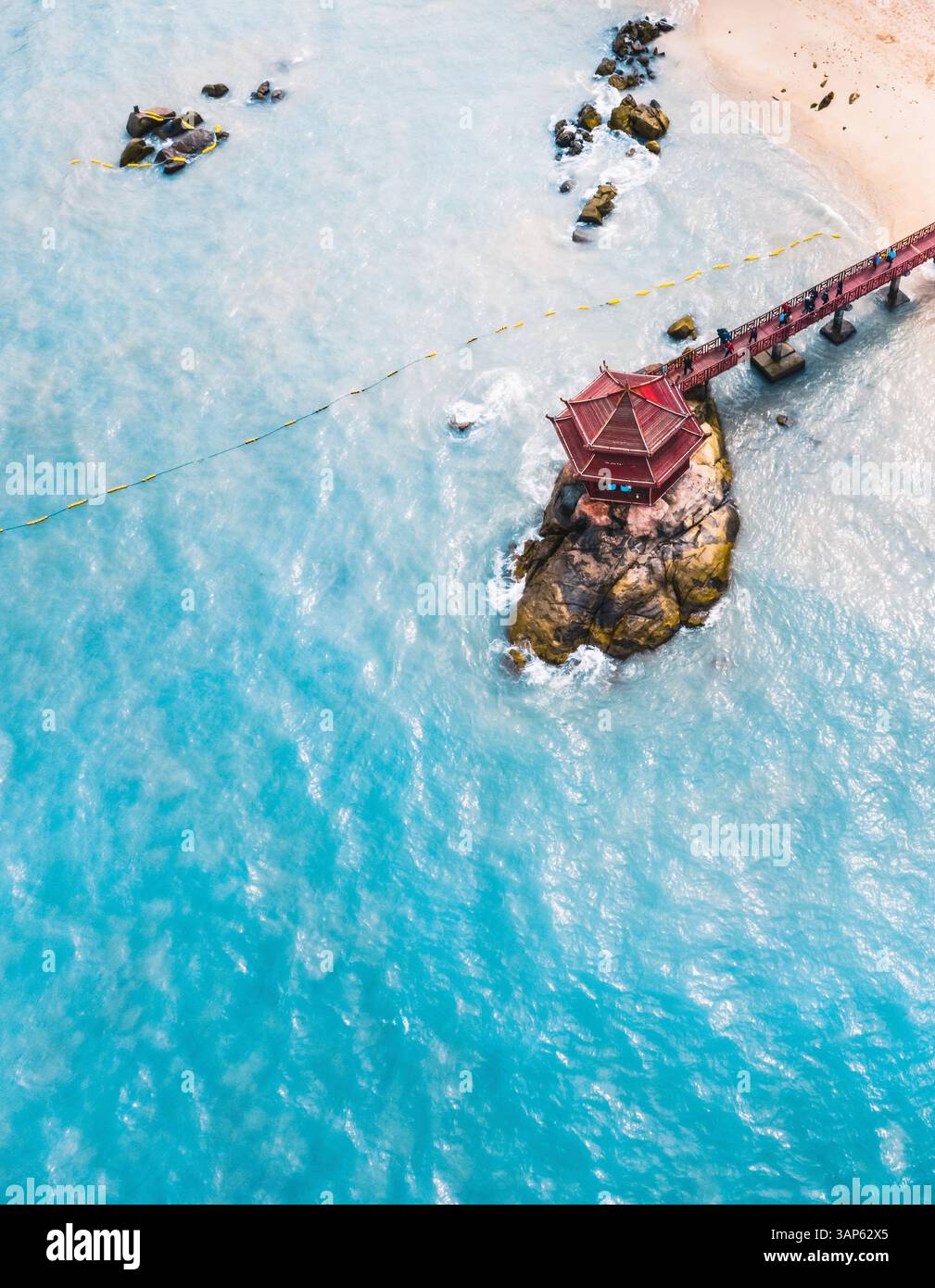 Aerial view of a small buddhist temple with a red pier along Ocean ...