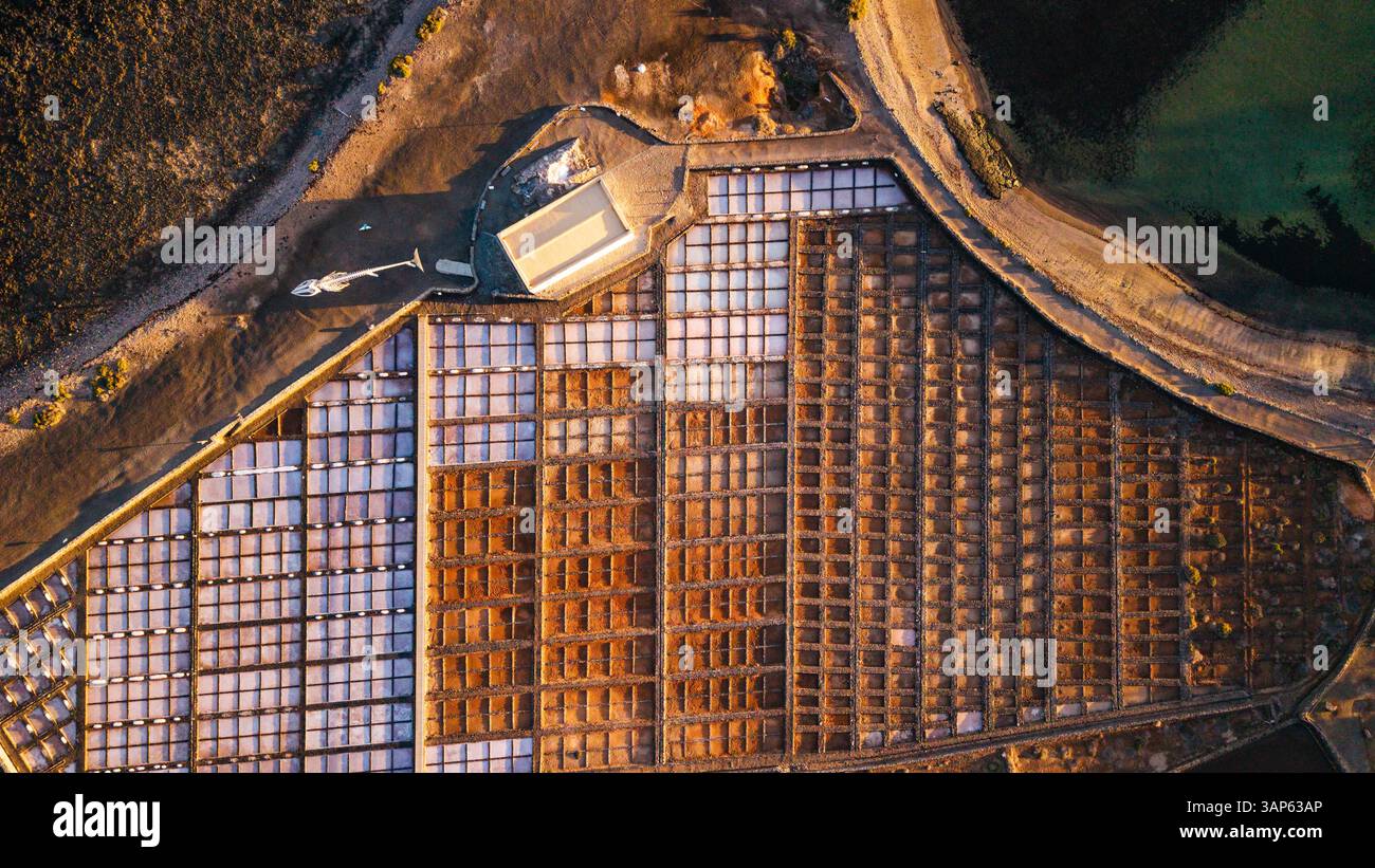 Aerial view of beautiful salt fields with geometric patterns at sunset ...