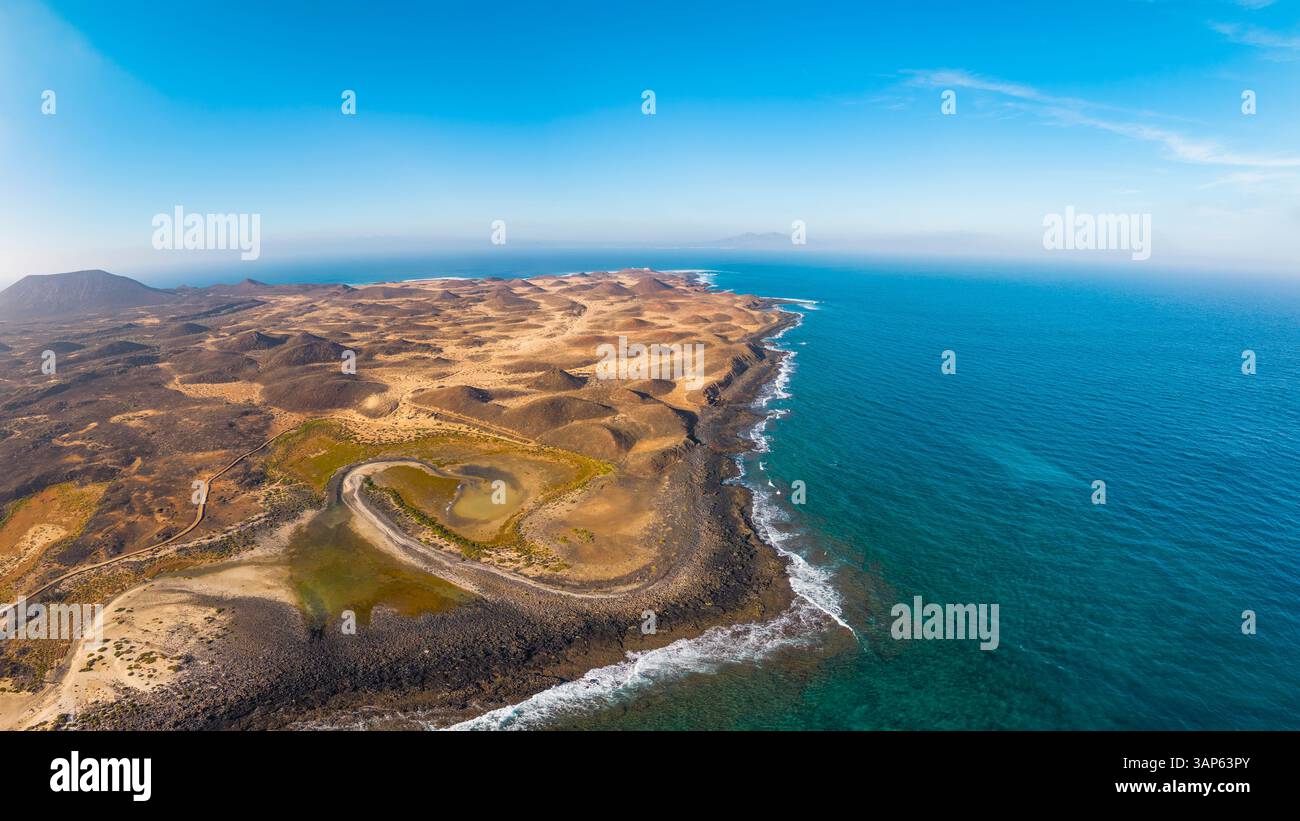Aerial view of rugged volcanic coast and serene ocean, Lobos Island ...