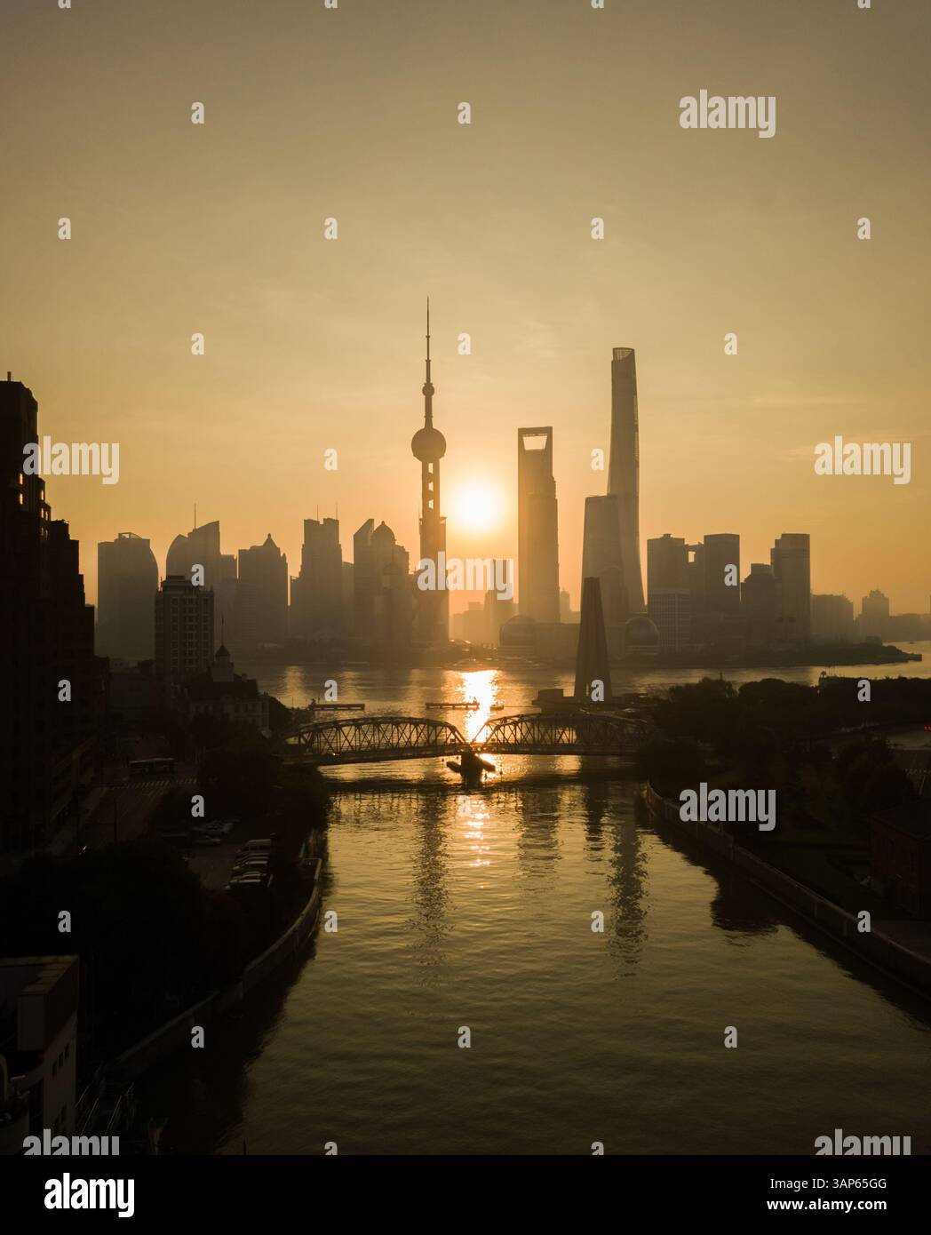 Aerial view of Shanghai skyline at sunset with passing Huangpu river ...