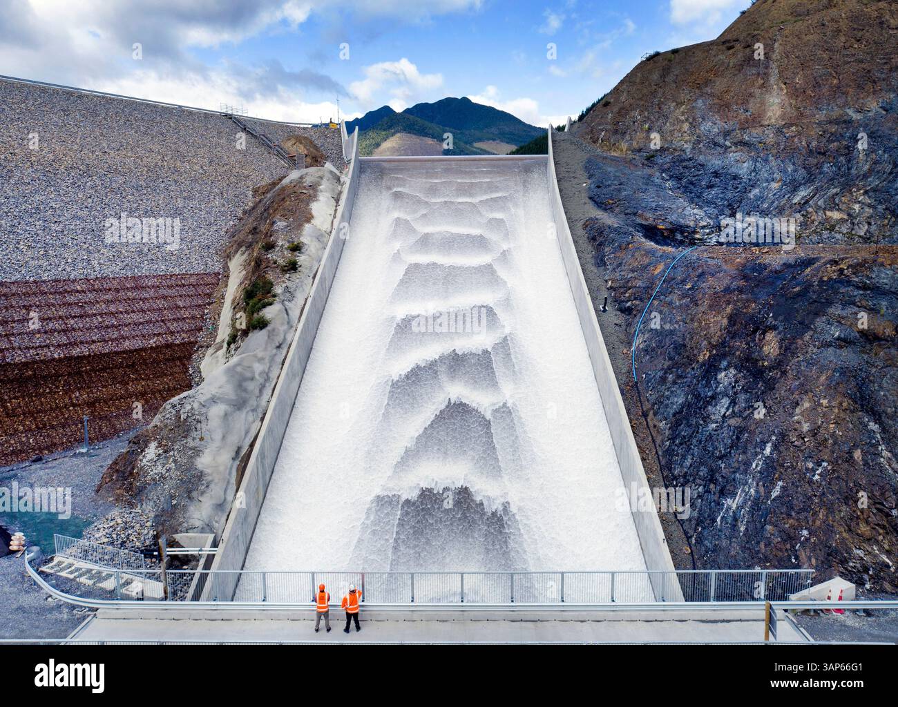 Aerial view of a scenic dam with a spillway and flowing water ...