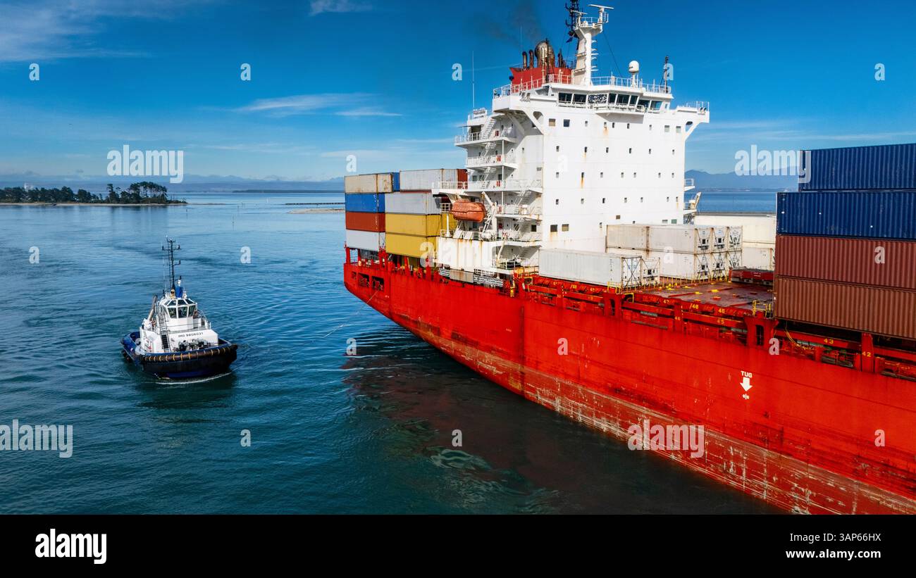 Aerial view of a pilot boat alongside a large container ship in a busy ...