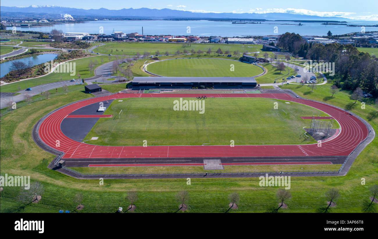 Aerial view of a scenic sports field and track surrounded by greenery ...