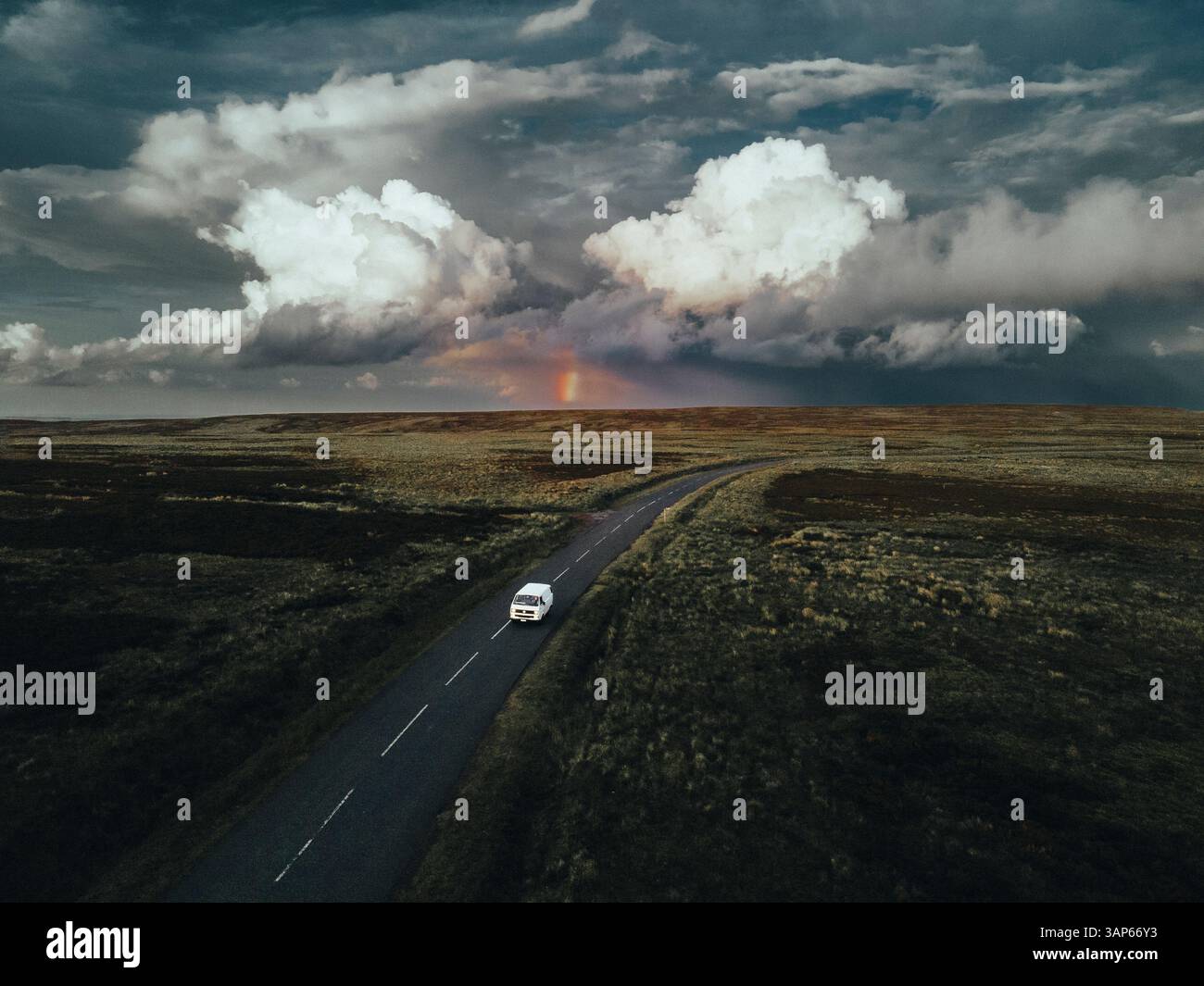 Aerial view of winding road through serene highlands under a dramatic ...