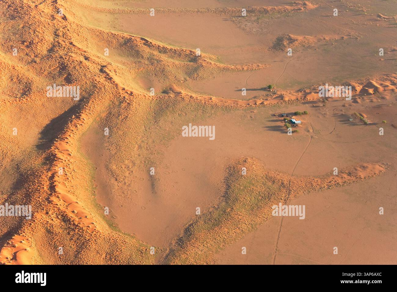 Aerial view of Farmhouse at the foot of a large grass-grown dune at the ...