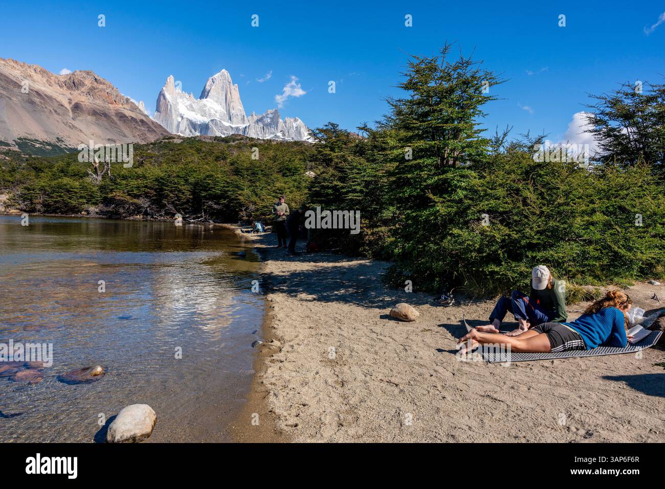 Young People Sitting By A Lake With A View of Mount Fitz Roy near The ...