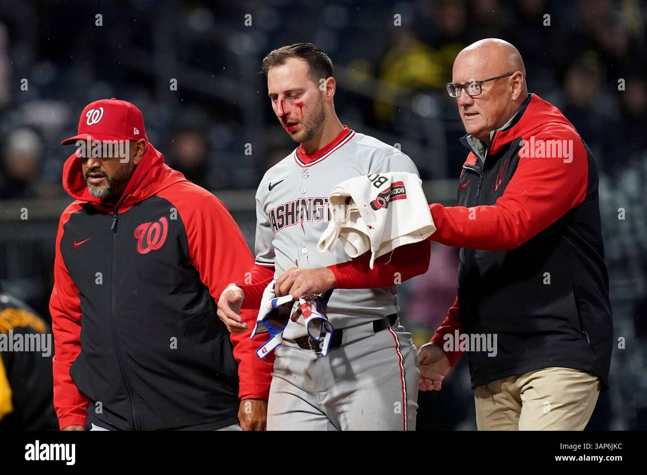 Washington Nationals' Paul DeJong, center, is helped off the field ...