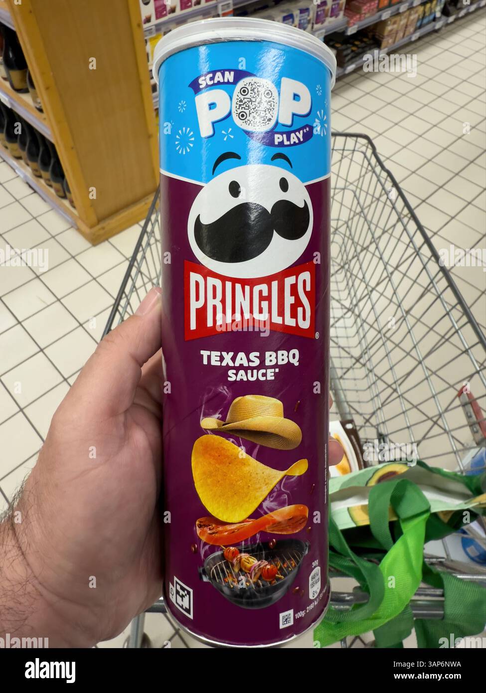 Hand holding a tube of Pringles Texas bbq sauce flavor chips in a ...