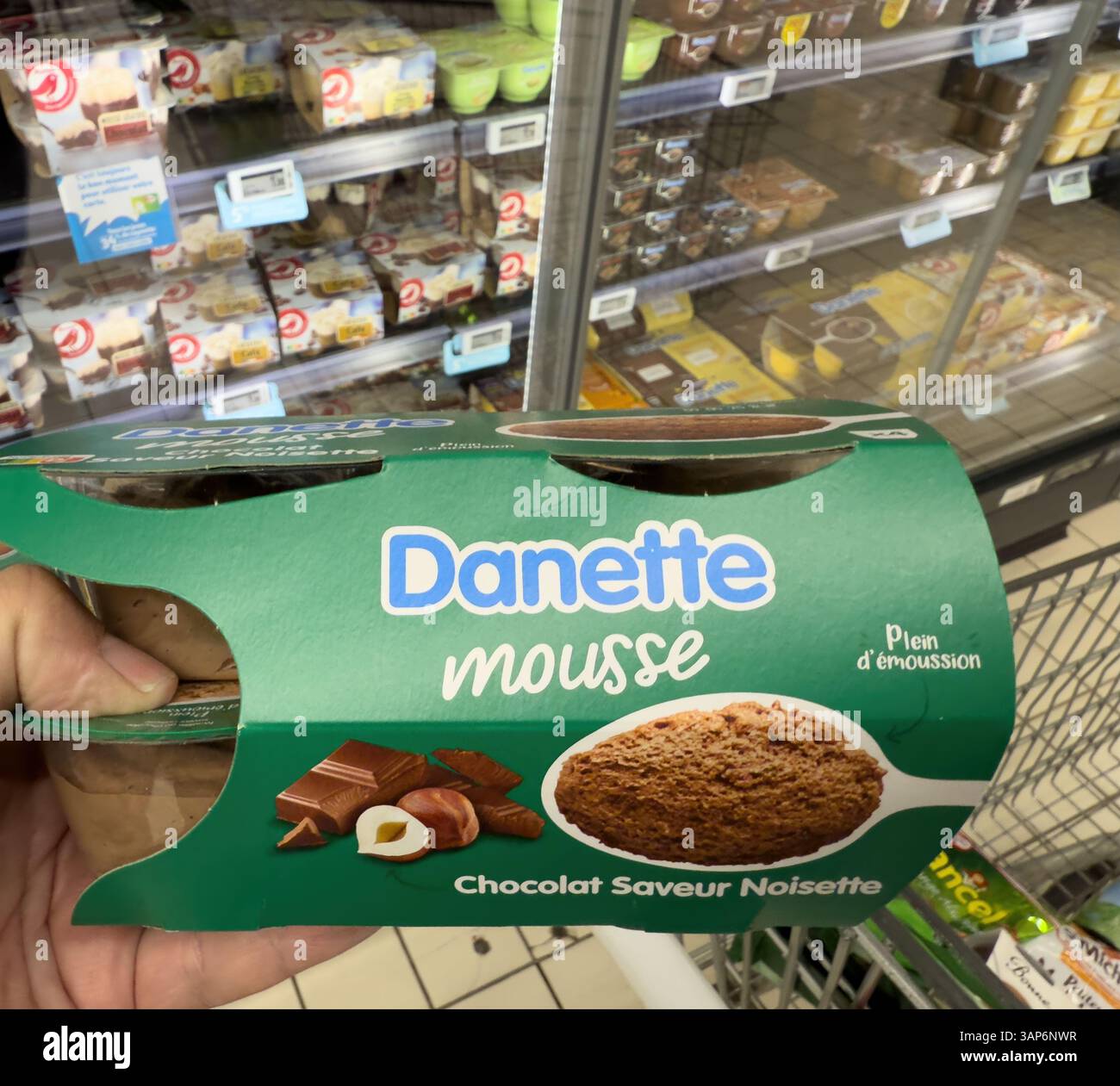 Hand holding a package of Danette chocolate hazelnut mousse in front of ...
