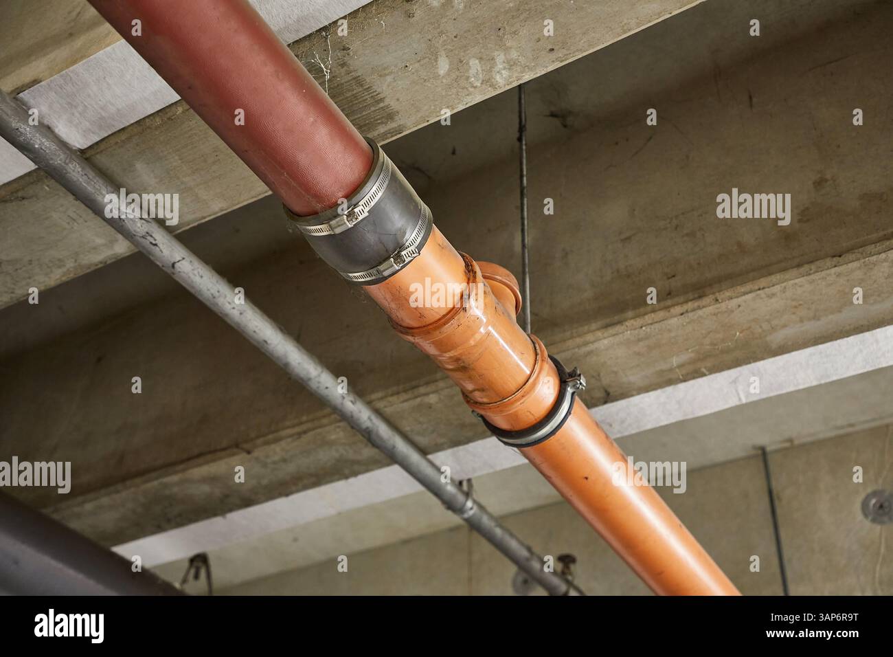 Pipelines below metal structure, utility tubes Stock Photo - Alamy