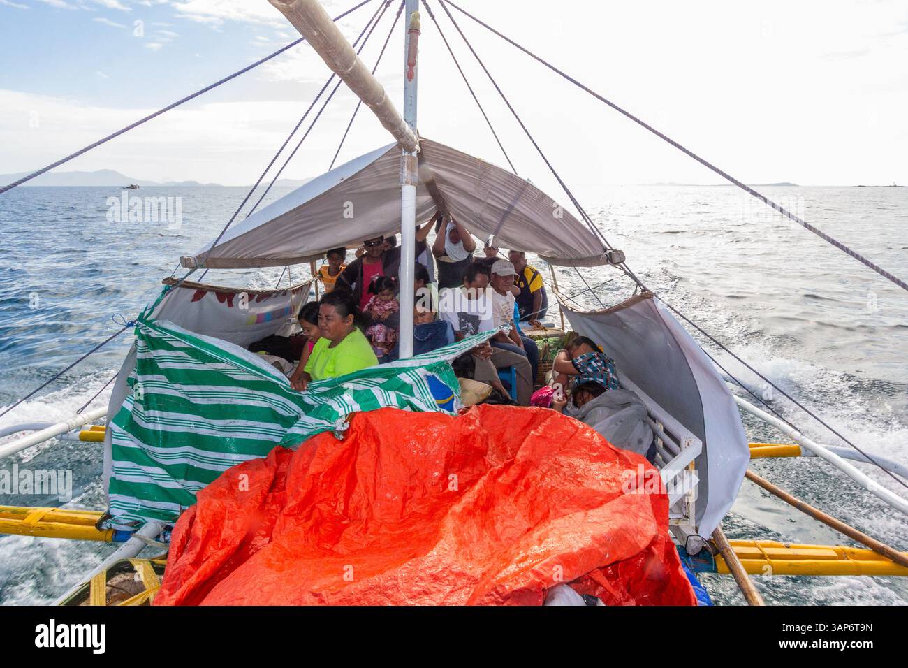 Local Filipino passengers sit inside a motorized boat as it travels ...
