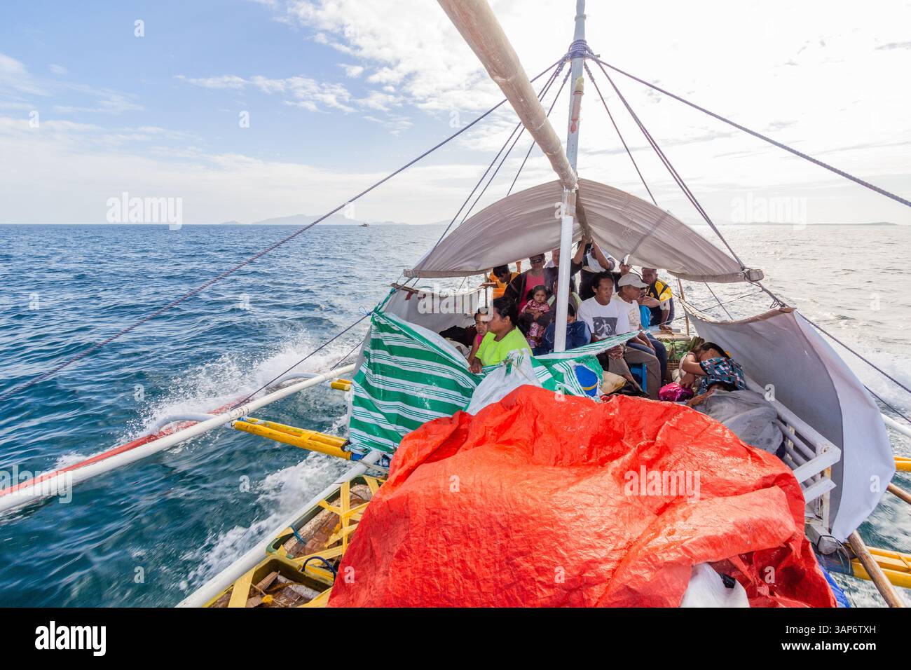 Local Filipino passengers sit inside a motorized boat as it travels ...