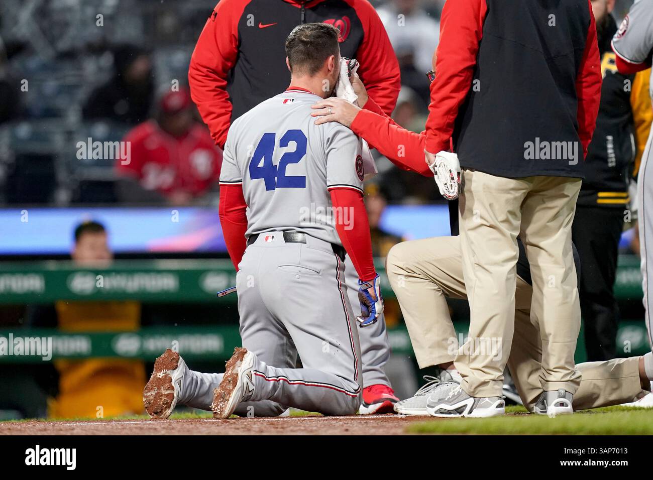 Washington Nationals' Paul DeJong, center, is attended to after getting ...