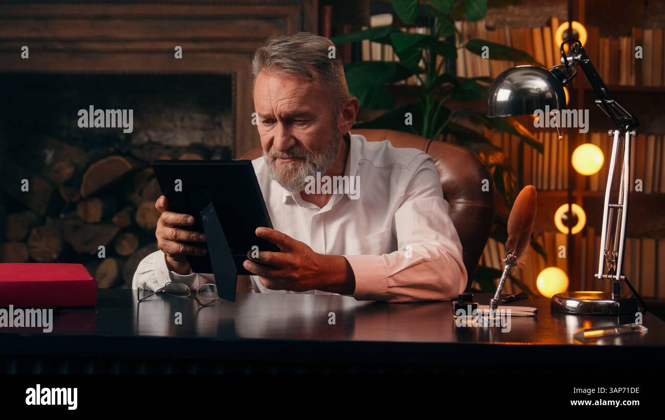 Sad Caucasian old man elderly male pensioner grandfather looking photo ...