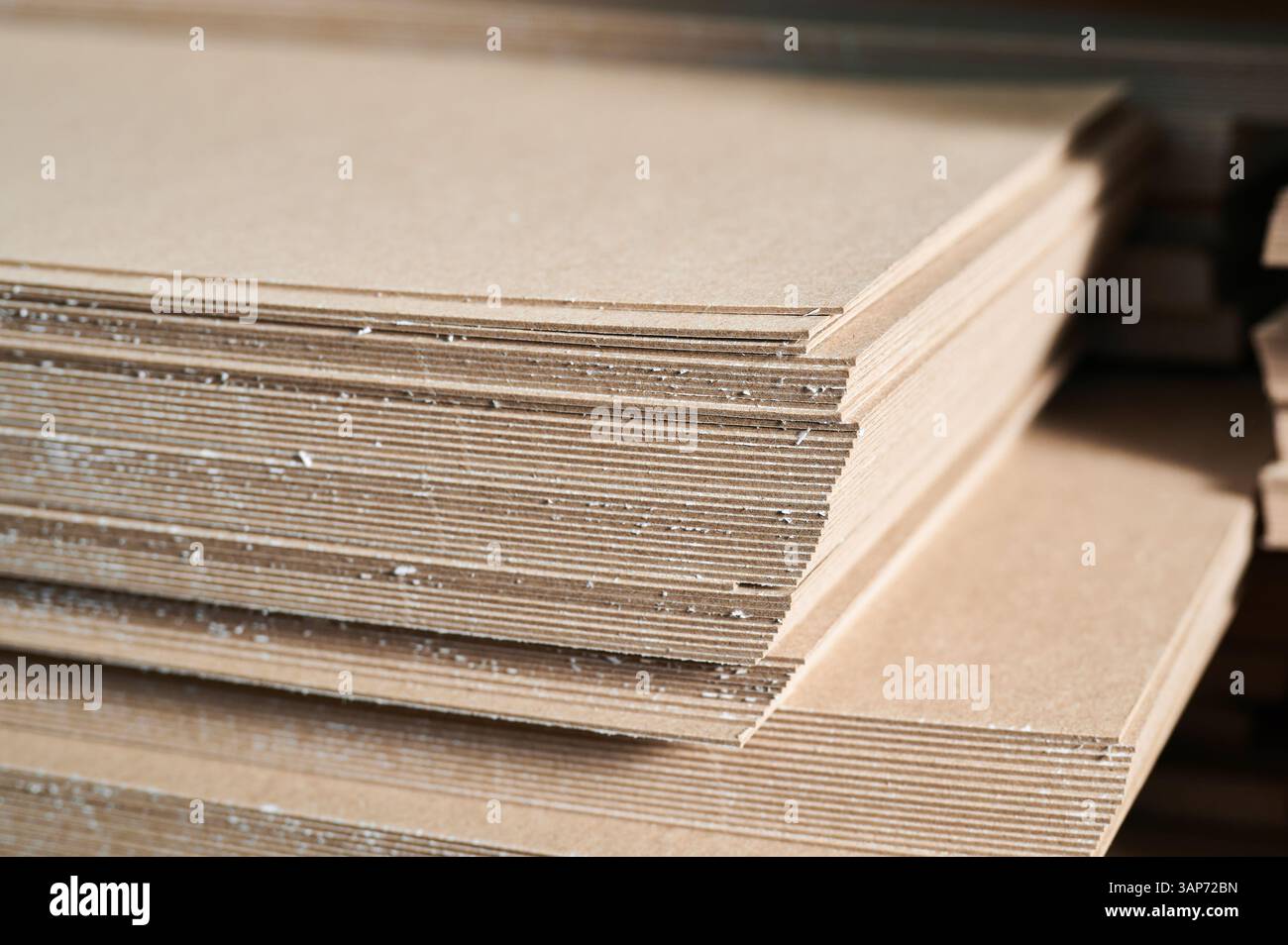 Stacks of thick paperboard ready for production of cardboard containers ...