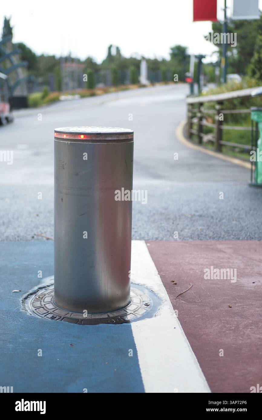 Modern metallic bollard on a colorful pavement at a roadway Stock Photo ...