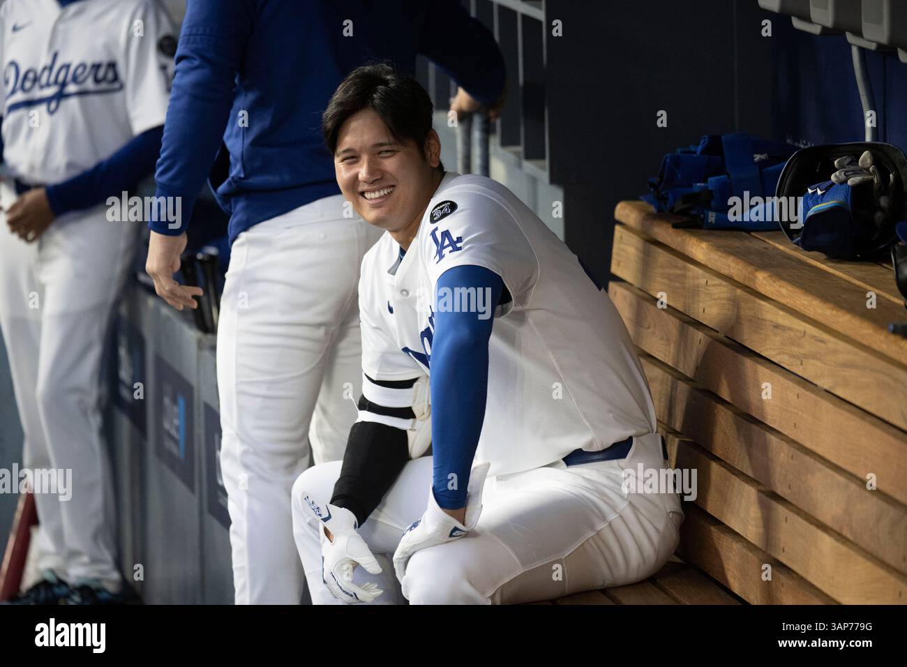 Los Angeles Dodgers' Shohei Ohtani smiles in the dugout during a ...