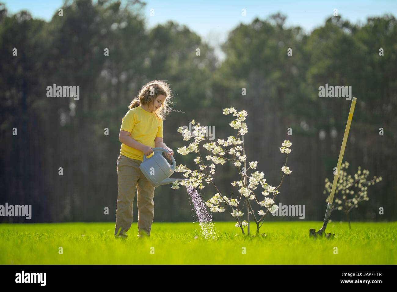 Kid growing a tree in garden. Kid digging soil with shovel and planting ...