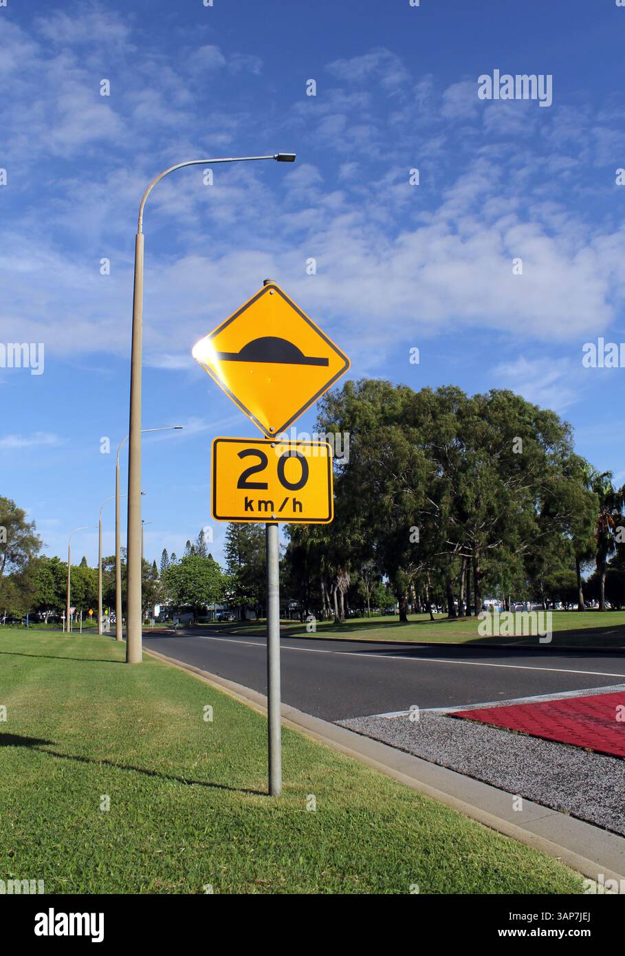 Speed bump warning sign and speed limit sign on the side of a road with ...