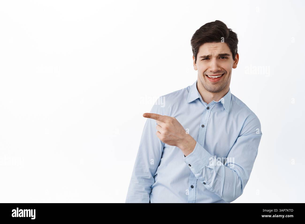 Cool and handsome young man in office clothes, pointing aside at promo ...