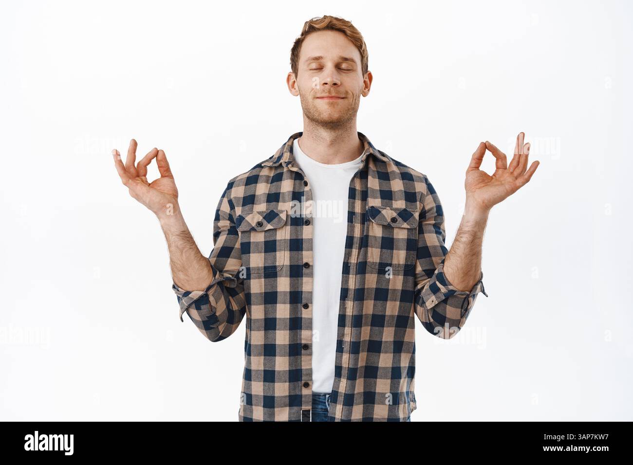 Redhead man close eyes and meditates with zen mudras, smiling and ...