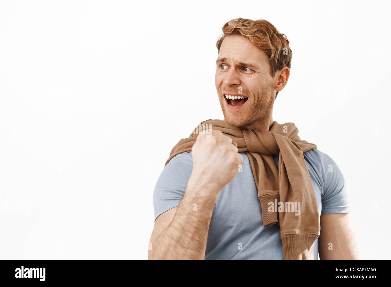 Successful handsome redhead man clench fist, say yes and triumphing ...