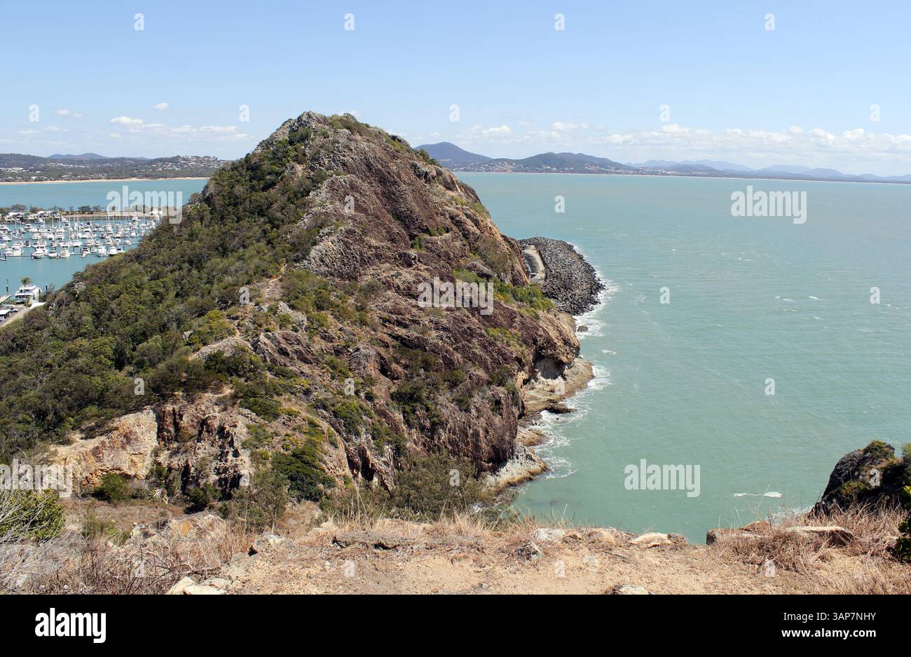 View of a mountain, the ocean, trees and boats from the Rosslyn Bay ...