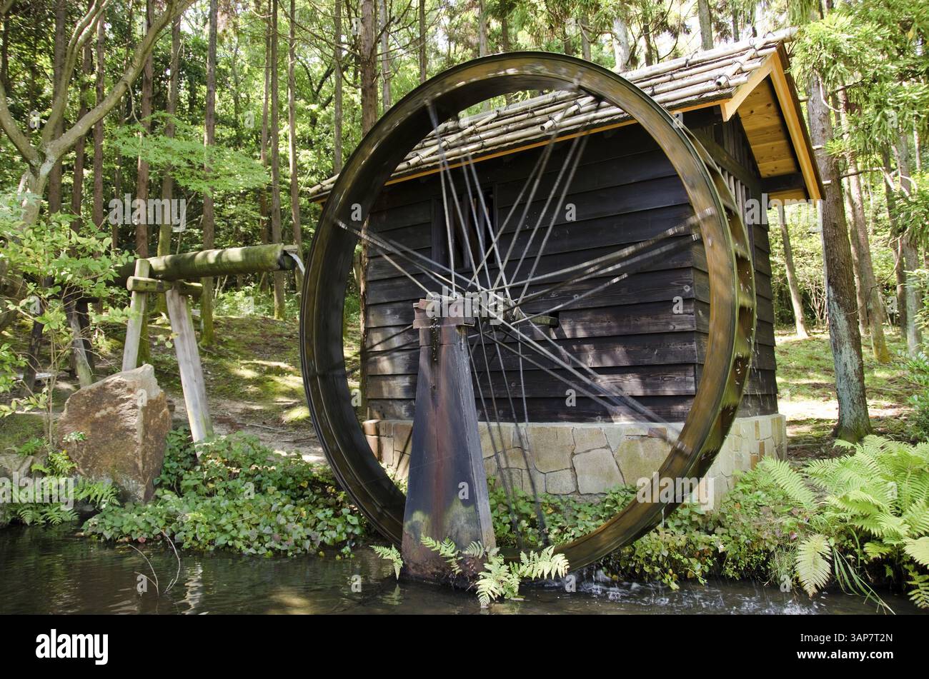Small Japanese water mill running in the Expo Commemorative Park, Osaka ...