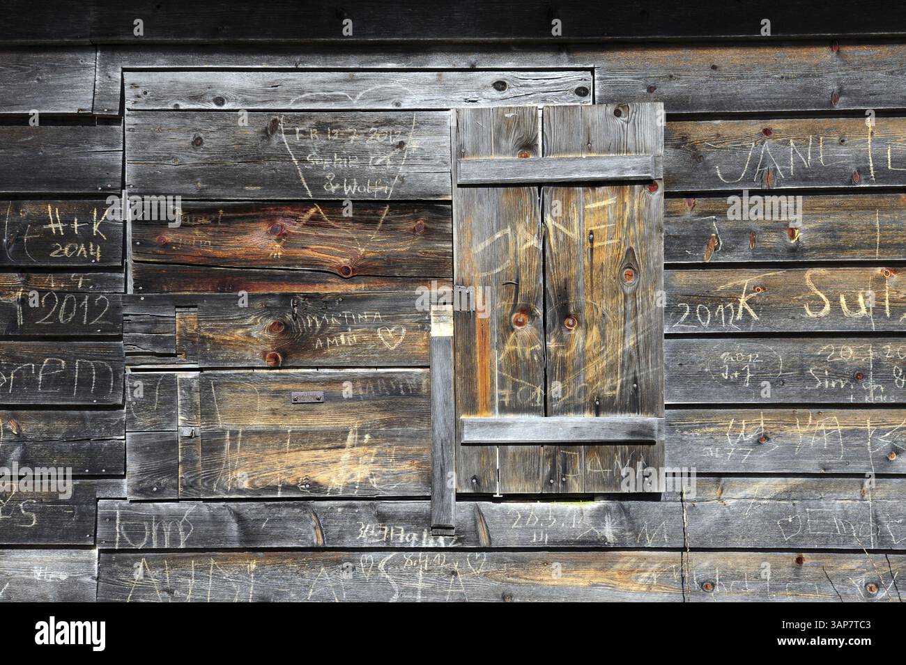 Carved love messages on the window flap of a log cabin, wooden house ...