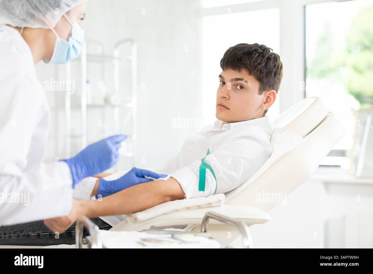 Anesthesiologist doctor injecting pain medication into vein of man ...