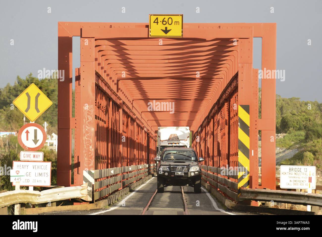Traffic crosses a single lane road-rail bridge over the Taramakau River ...