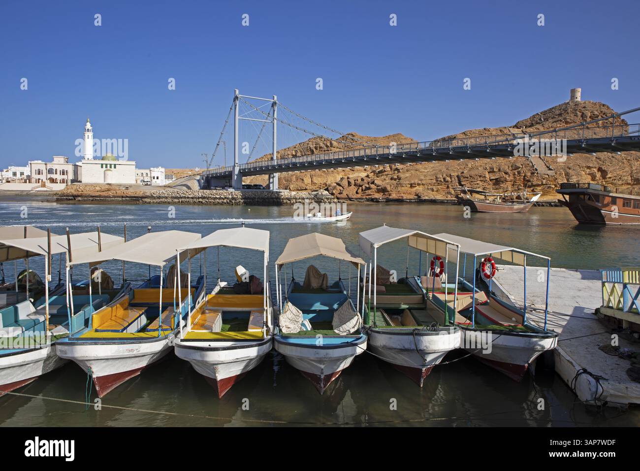 Suspension bridge Al-Ayja on the Gulf of Oman, in front excursion boats ...