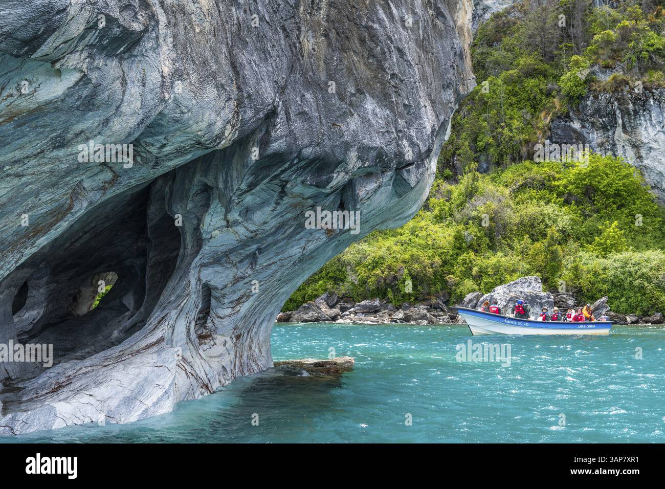 Motorboat with tourists at the rock formation of the marble chapel ...