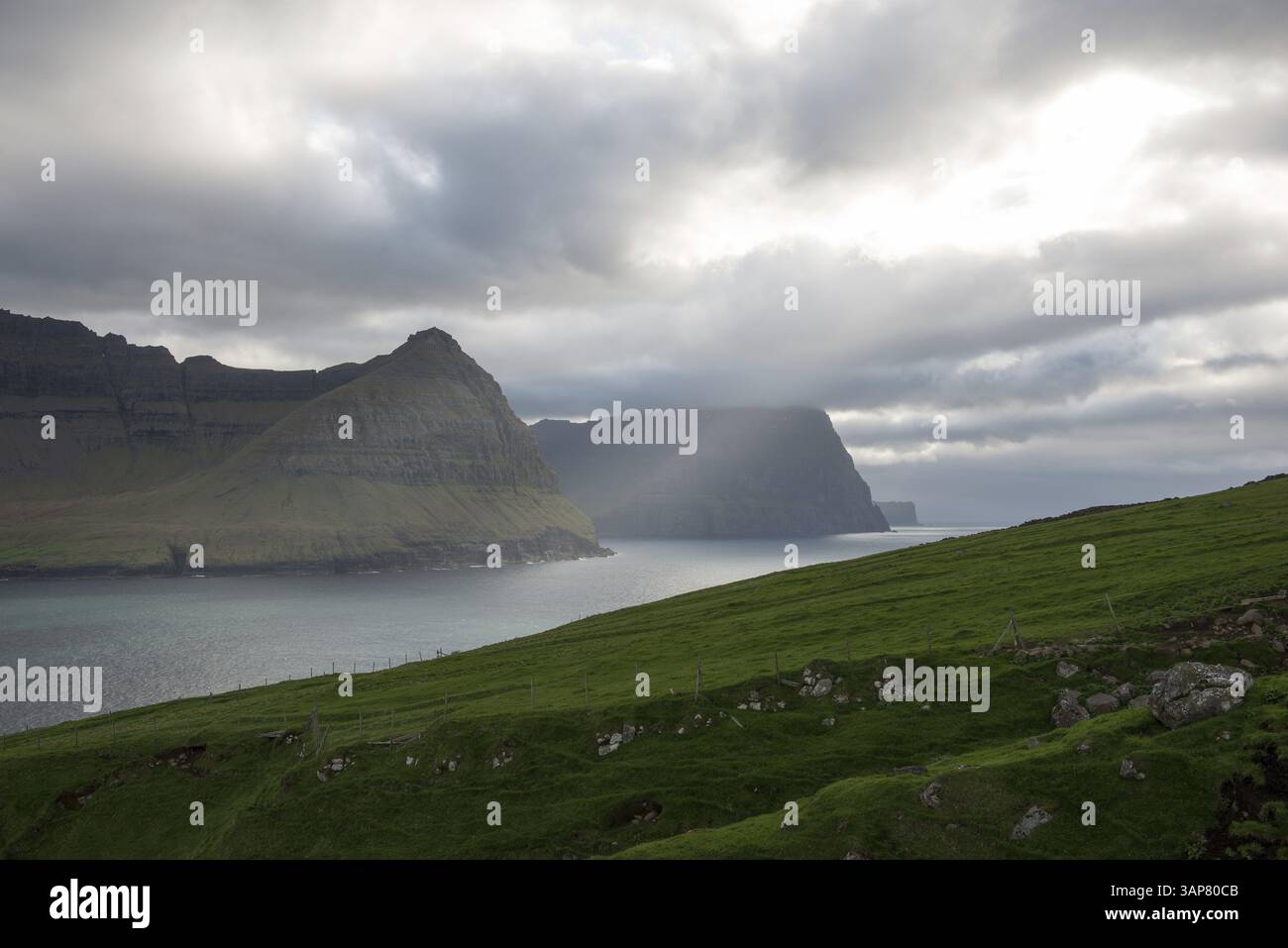 Typical landscape on the Faroe Islands, with green grass and rocks as ...