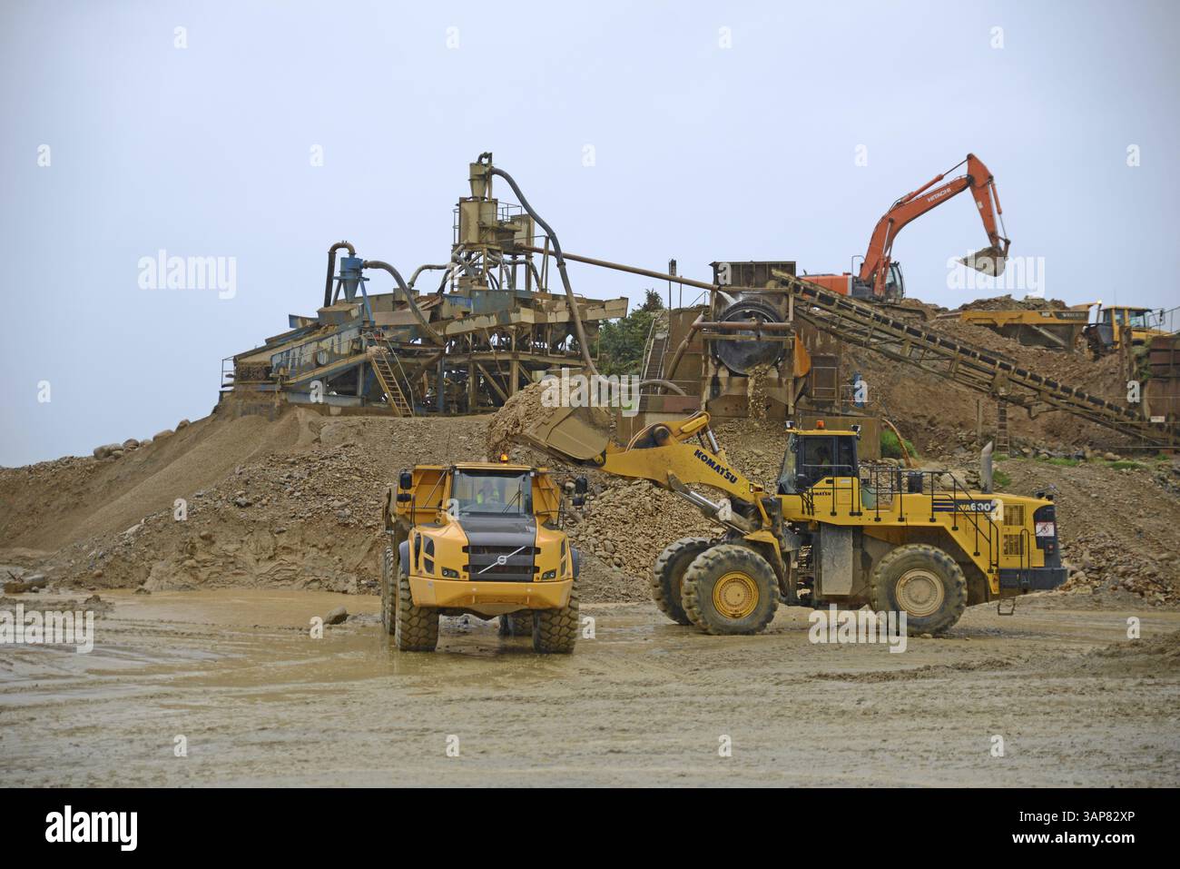 A payloader loads a tip truck with spoil after processing for gold at a ...