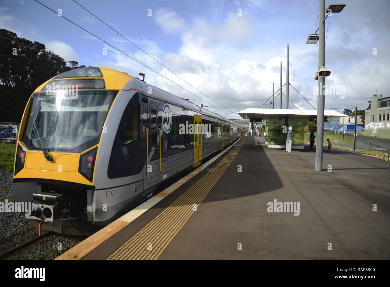 A commuter train waits for passengers at a suburban Auckland train ...